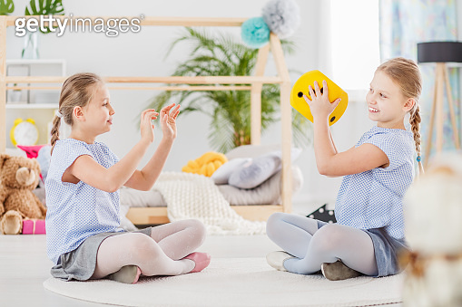 Twin sisters playing yellow ball 이미지 (932797736) - 게티이미지뱅크