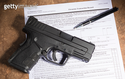 Background check for a gun purchase with a handgun (920395072) - 게티이미지뱅크