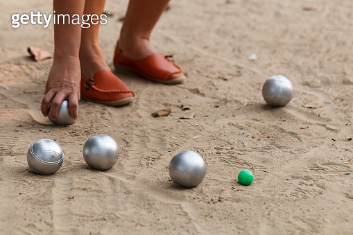 Boules and green jack ball in the match and player in back (949103268 ...