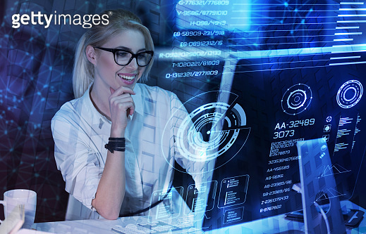 Happy programmer looking at the transparent screen of a computer and ...