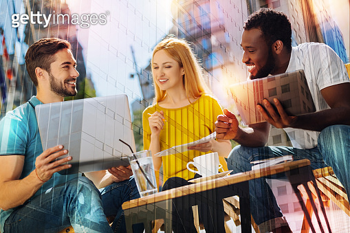 Friendly young people smiling while holding laptops and talking 이미지 ...