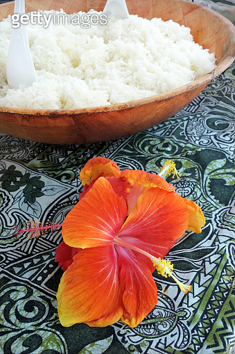 Bowl of rice served with red hibiscus flower decoration in Rarotonga ...