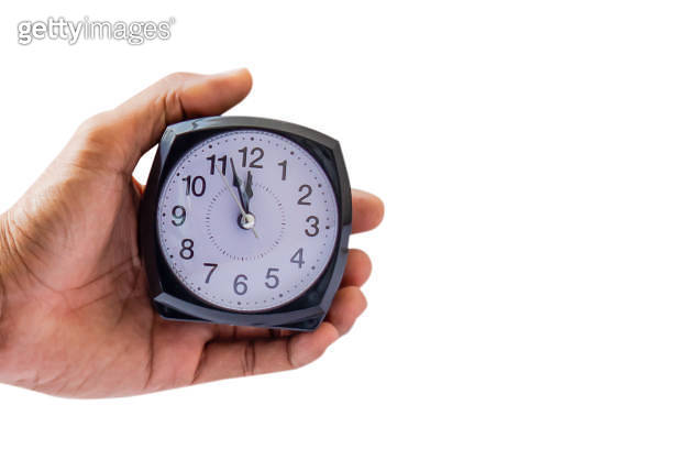 Holding clock on isolated background The time 12:00 am or pm and noon ...