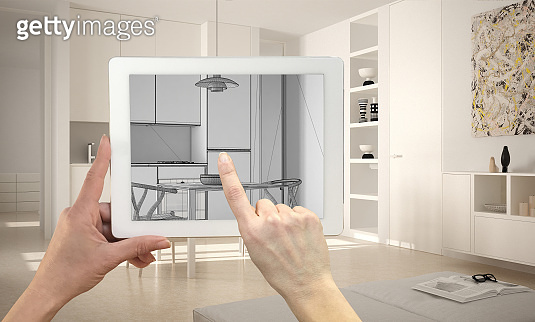 Hands holding and pointing on tablet showing modern kitchen CAD sketch ...