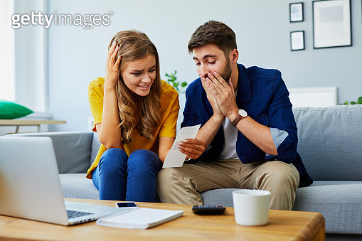 Front view of a stressed young couple facing financial problems ...