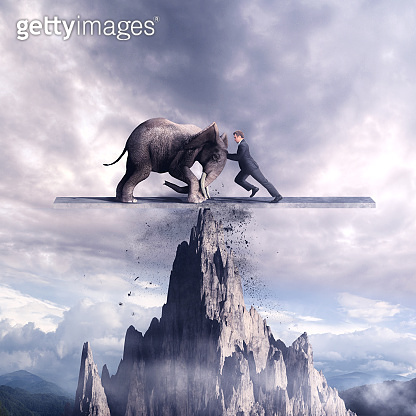 Man and an elephant pushing eachother on a balance above mountain rock ...