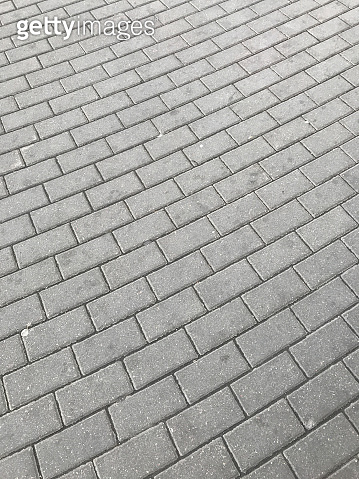 Geometric pavement design with grey tiles. Perspective of urban ...