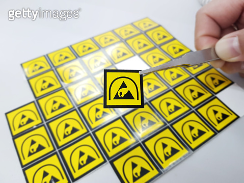 Hand holding ESD symbol label with tweezers,Electrostatic Sensitive ...