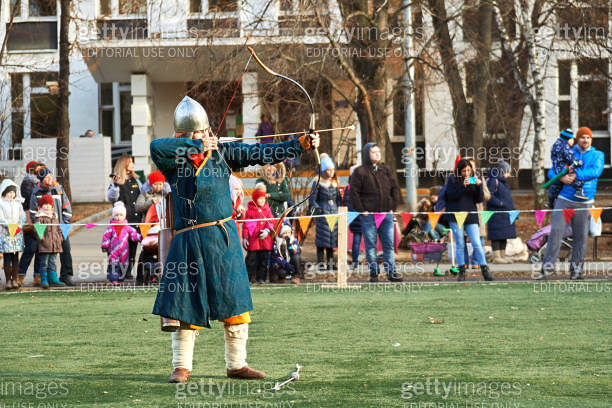 Medieval archer shoots an arrow from a bow. Reconstruction of a ...