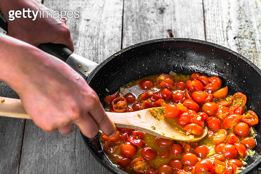 Chef cooking italian dish with fried tomatoes, sauce for pasta, healthy ...