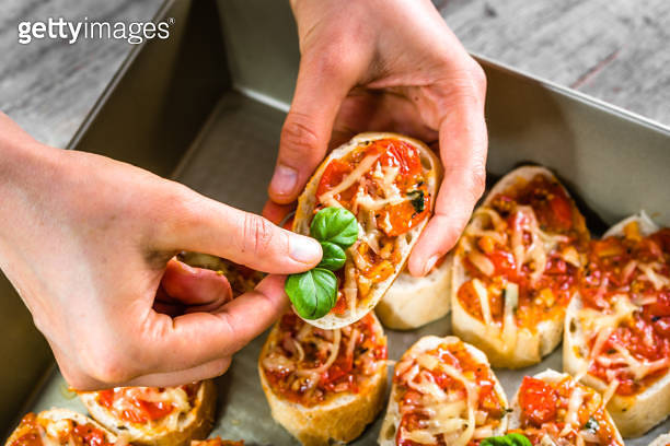 Chef in restaurant cooking italian food - bruschetta with baked ...
