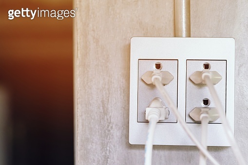 White rubber plug power line is electrical plugged into the power ...