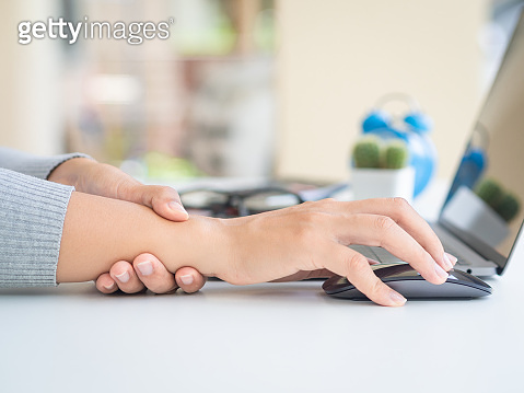 Closeup woman holding her wrist pain from using computer long time ...