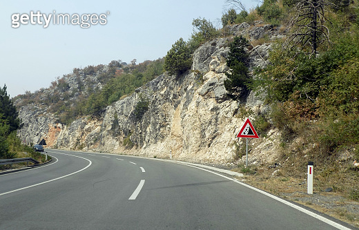 Road sign of the danger of slashing on the road through the rocky ...