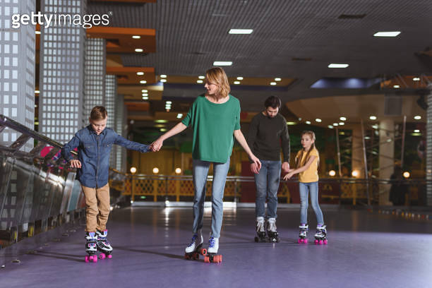 parents and kids skating on roller rink together (1007094272) - 게티이미지뱅크