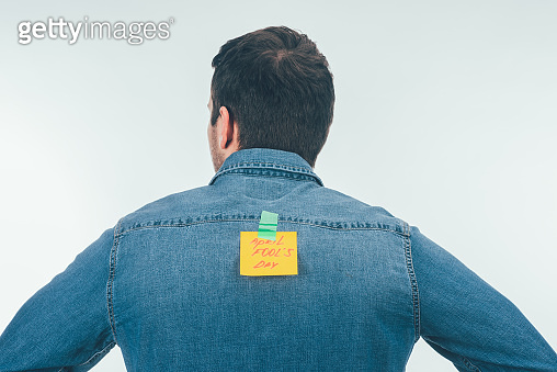 back view of man with note on sticky tape with april fools day ...