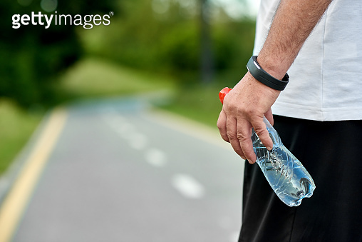Sportsman's hand keeping water bottle runningon racetrack. 이미지 ...