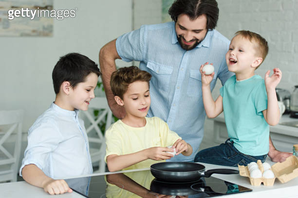 portrait of family cooking breakfast together in kitchen at home 이미지 ...