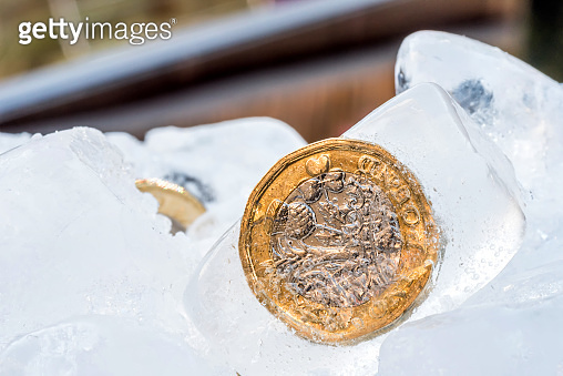 Frozen New British one pound sterling coin up close macro inside ice ...