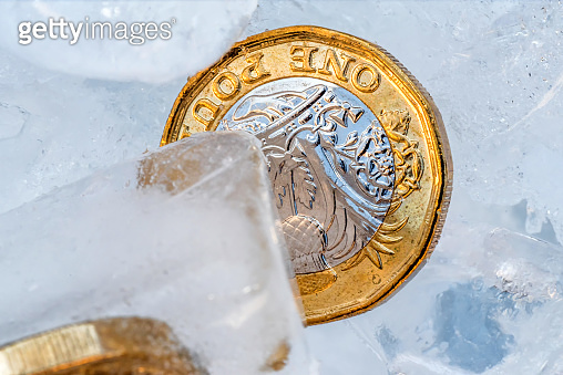 Frozen New British one pound sterling coin up close macro inside ice ...