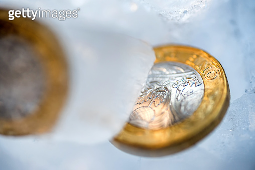 Frozen New British one pound sterling coin up close macro inside ice ...