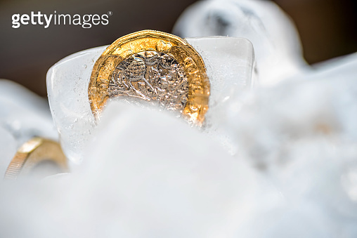 Frozen New British one pound sterling coin up close macro inside ice ...