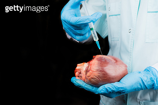 The medical worker makes an injection of the drug into the heart. Dark ...