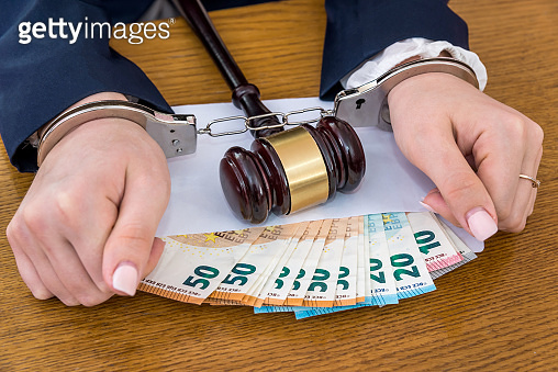 Female hands in handcuffs with money and judge gavel (959837660) - 게티이미지뱅크