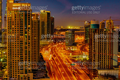 Traffic streams on a highway through town, running past skyscrapers 이미지 ...