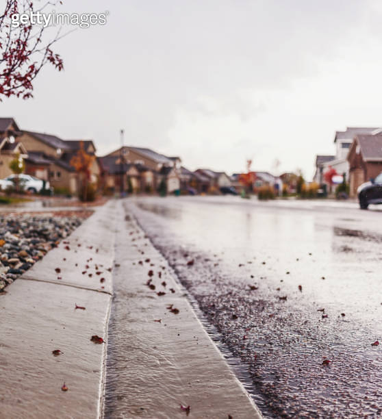 Low angle street view of heavy rainfall in residential small town ...