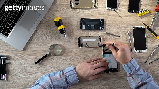 Repair specialists upgrading and maintaining gadgets, examining broken ...