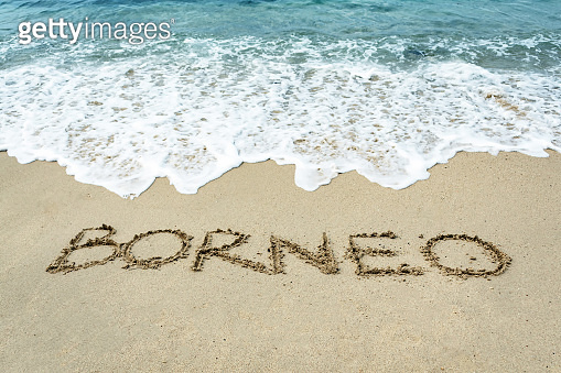 BORNEO text written on sand beach with waves (1072179052) - 게티이미지뱅크