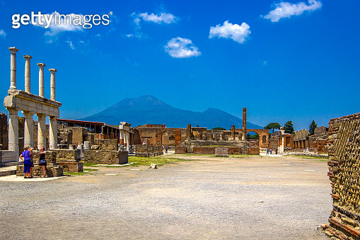 View of the ancient city, the ruined ancient columns and the volcano ...