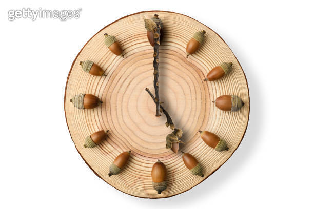 Isolated shot of a acorn clock pointing 5 o'clock on white background ...