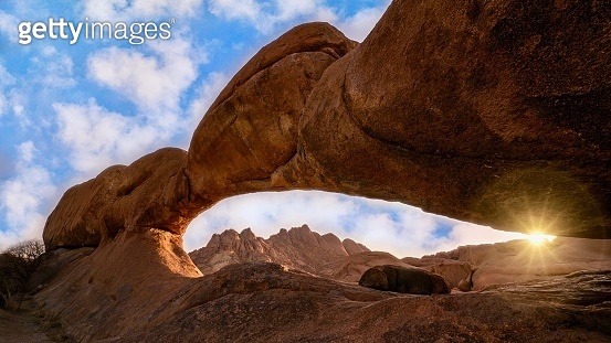 Ancient granite rock forming a natural arch in the Namib Desert, at ...