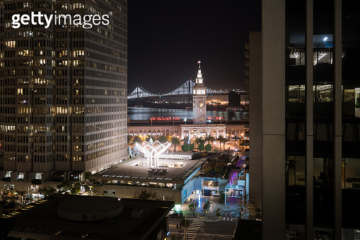 View of the illuminated Ferry Building, commerical office buildings and ...