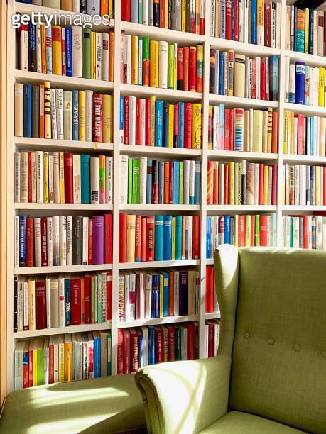 Green reading chair and bookshelves in background 이미지 (1047027882) - 게티 ...