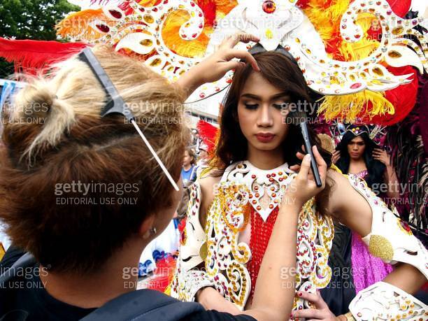 A make up artist applies make up to a parade participant in her ...