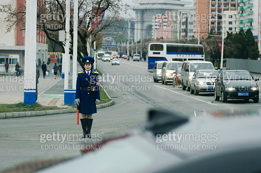 Police woman controlling traffic at Pyongyang (957849416) - 게티이미지뱅크