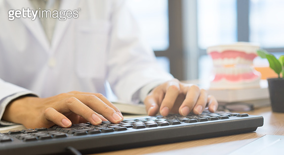 close up dentist hand typing on computer keyboard for fill out or ...