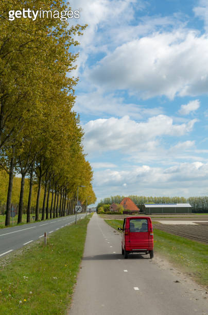 Small red disabled car on bicycle lane in dutch polder (1026672294 ...