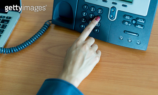 close up employee woman finger pressing number on telephone VOIP ...