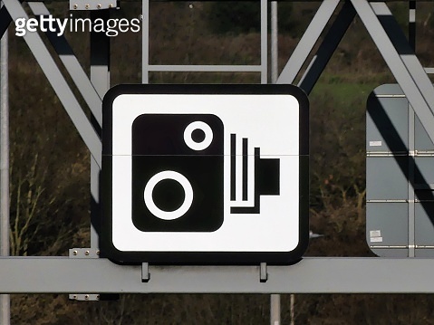 Speed camera sign on gantry above the M25 Motorway in Hertfordshire ...