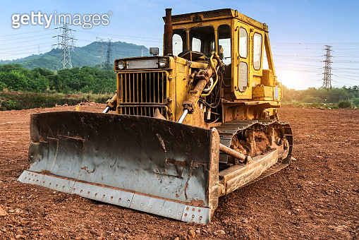 Bulldozer construction in the field, far away from electric piles and ... Bulldozer construction in the field, far away from electric piles and ...