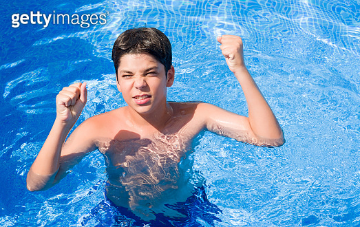 Young child on holidays at the swimming pool by the beach annoyed and ...