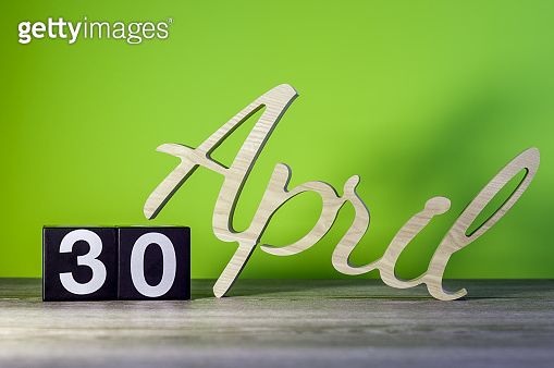 April 30th. Day 30 of month, calendar on wooden table and green ...