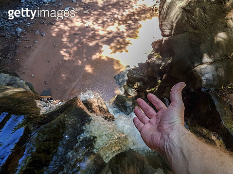 hand outstretched over a cascade 이미지 (907065842) - 게티이미지뱅크