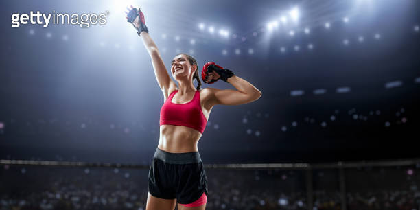 Female MMA fighter rejoices in victory in professional boxing ring 이미지 (1058019858) - 게티이미지뱅크