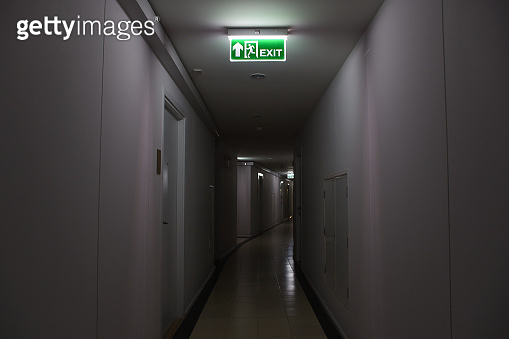 Emergency fire exit sign show the way to escape and low light in walk ...
