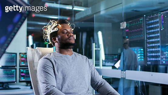 Man Wearing Brainwave Scanning Headset Sits in a Chair With Closed Eyes ...